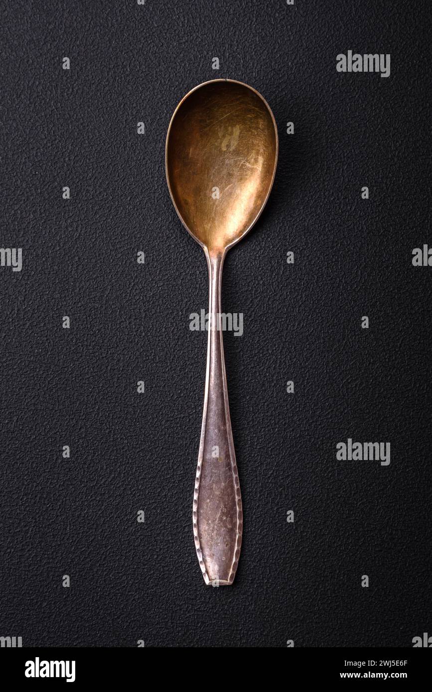 Empty metal spoon on dark textured concrete background Stock Photo - Alamy