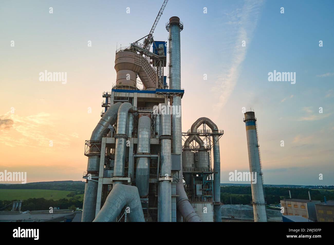 Cement plant with high factory structure and tower cranes at industrial ...