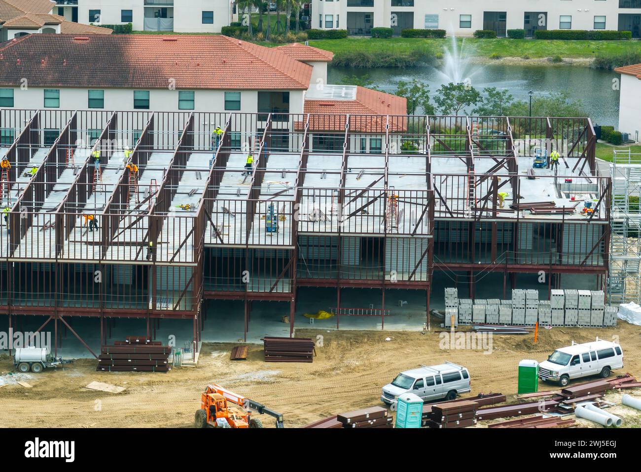 Construction works on metal walls of commercial building. Blue collar ...
