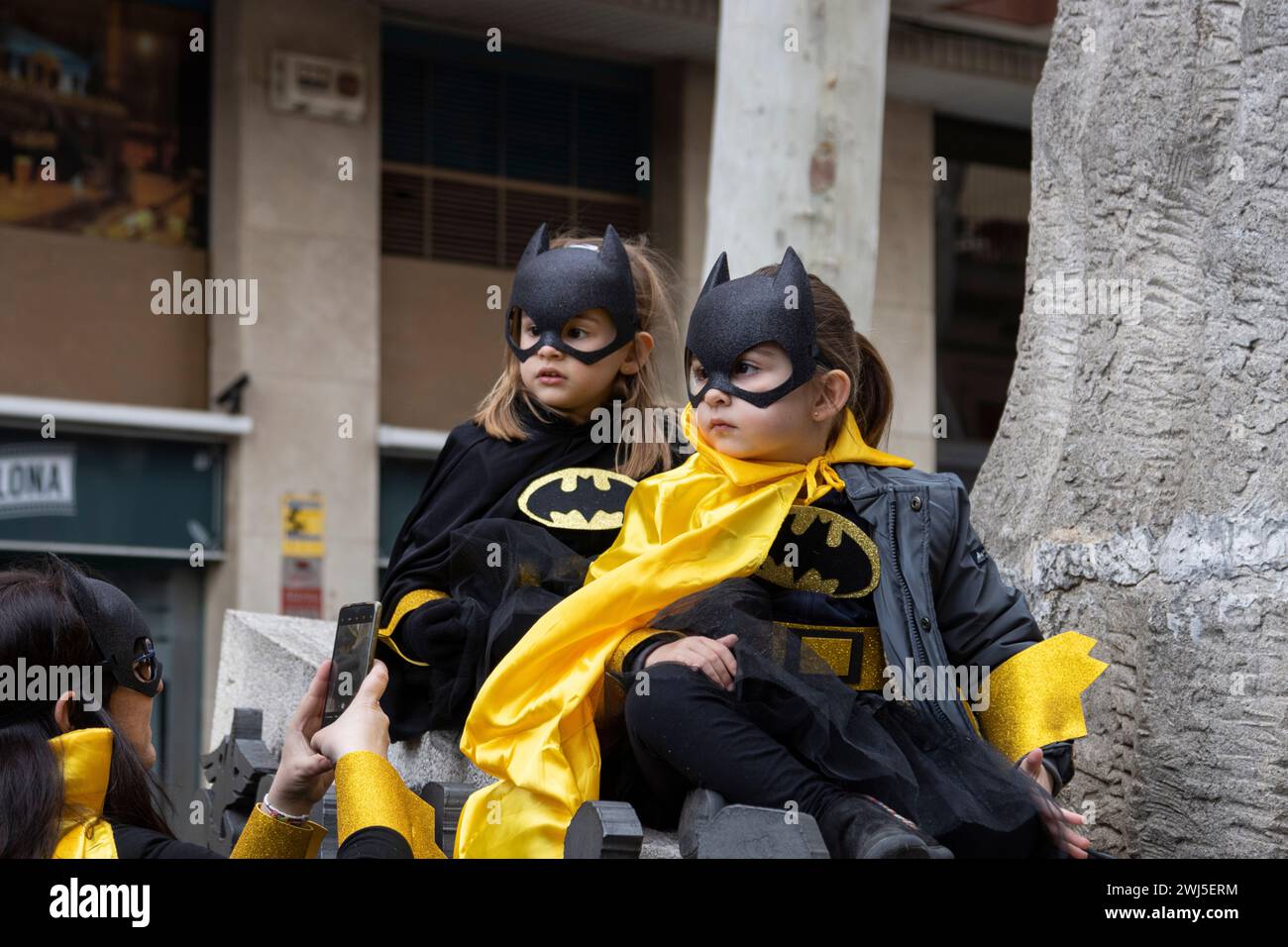 Two young kids in Batman and Batgirl costumes during the carnival in ...
