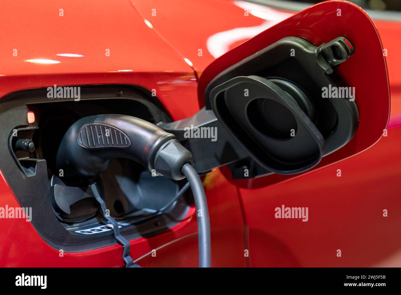 Electric car (EV) is charging in socket with cable Stock Photo - Alamy
