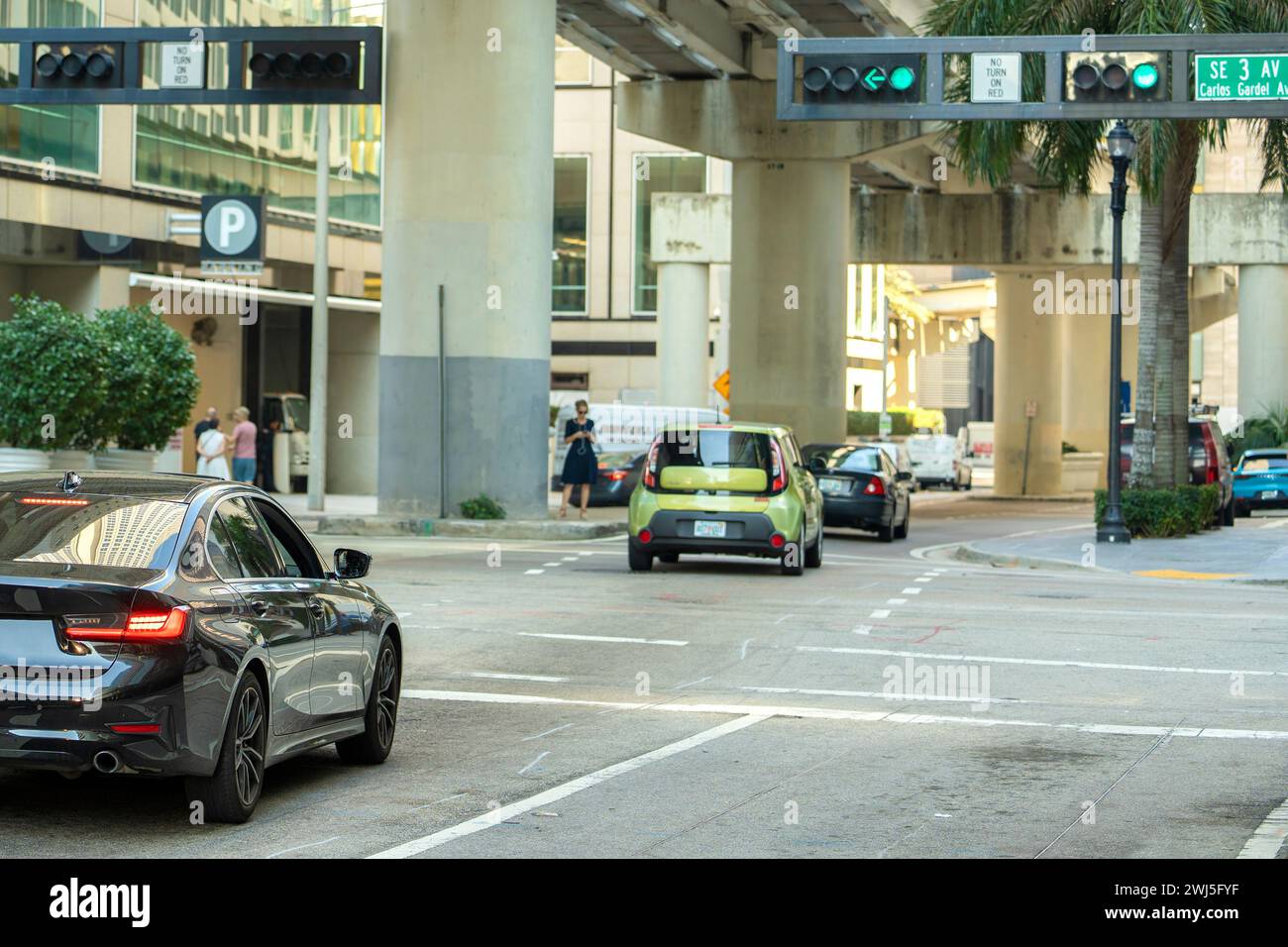 Miami street traffic with driving cars at urban intersection with ...