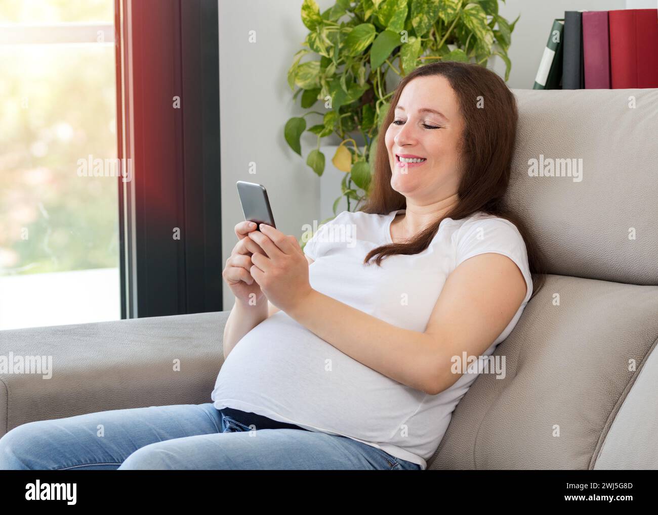 Pregnant woman smiling looking screen hi-res stock photography and ...