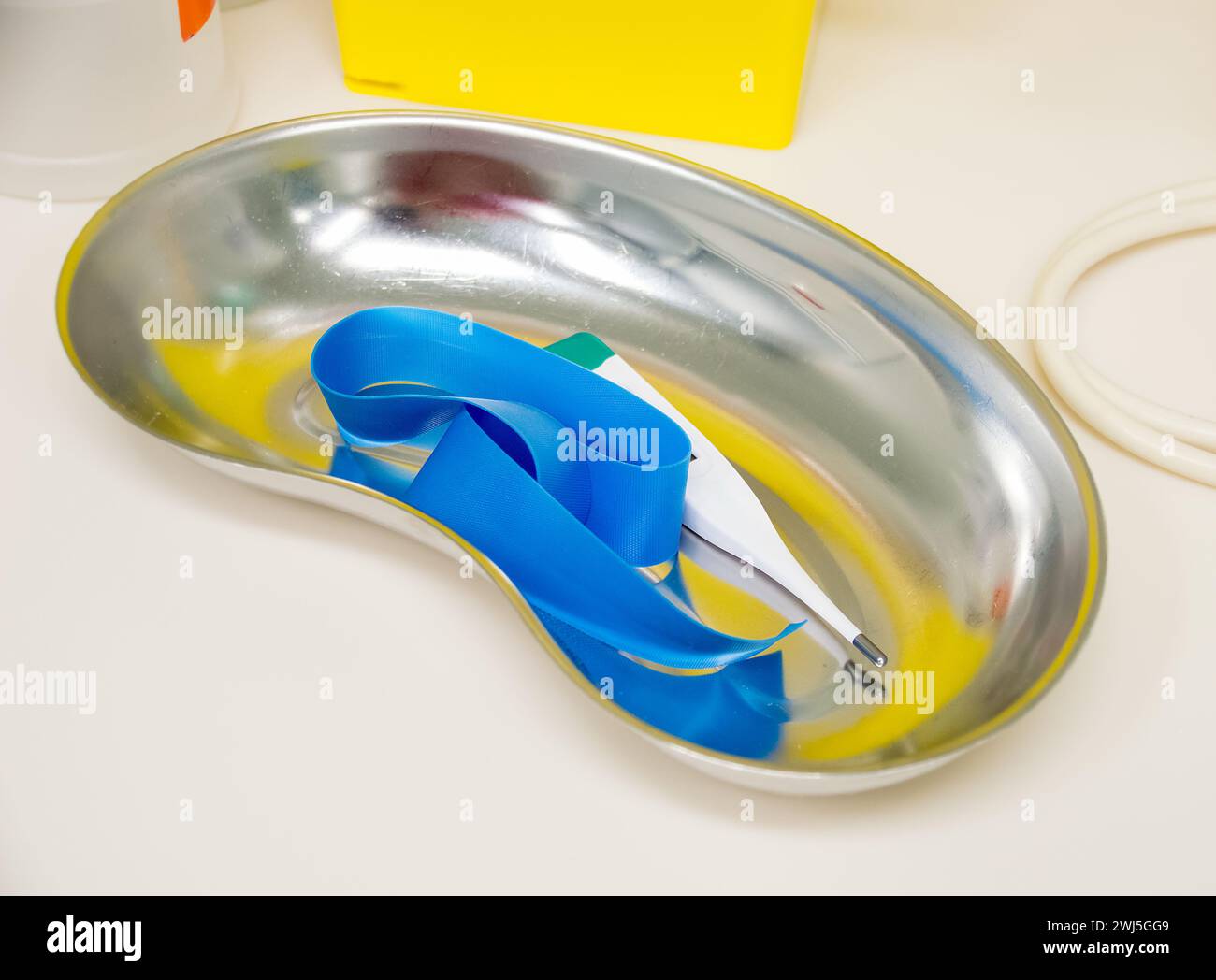 Metal tray with a digital thermometer and a blue tourniquet band at ...