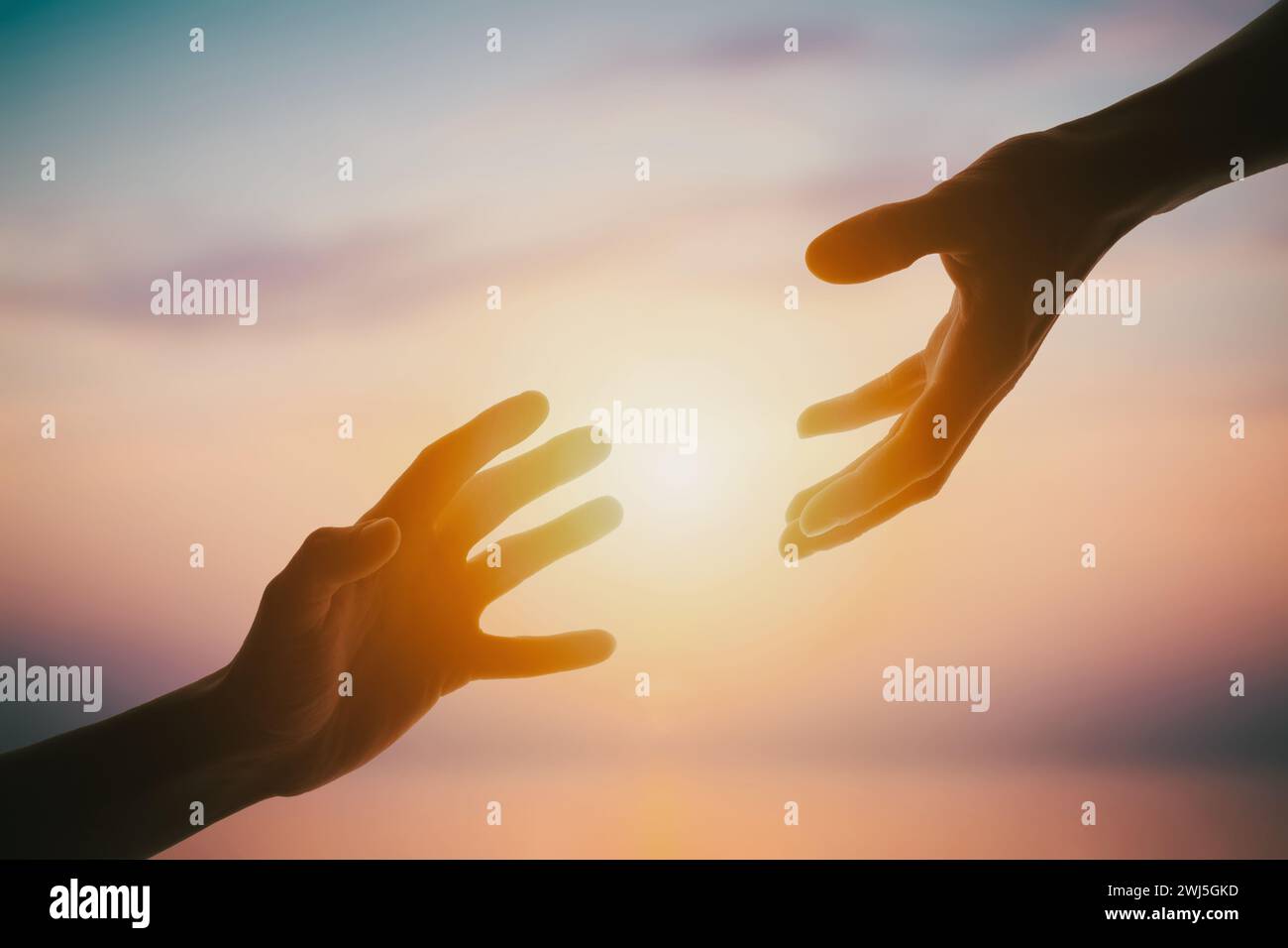 Giving a helping hand on sunset Stock Photo - Alamy