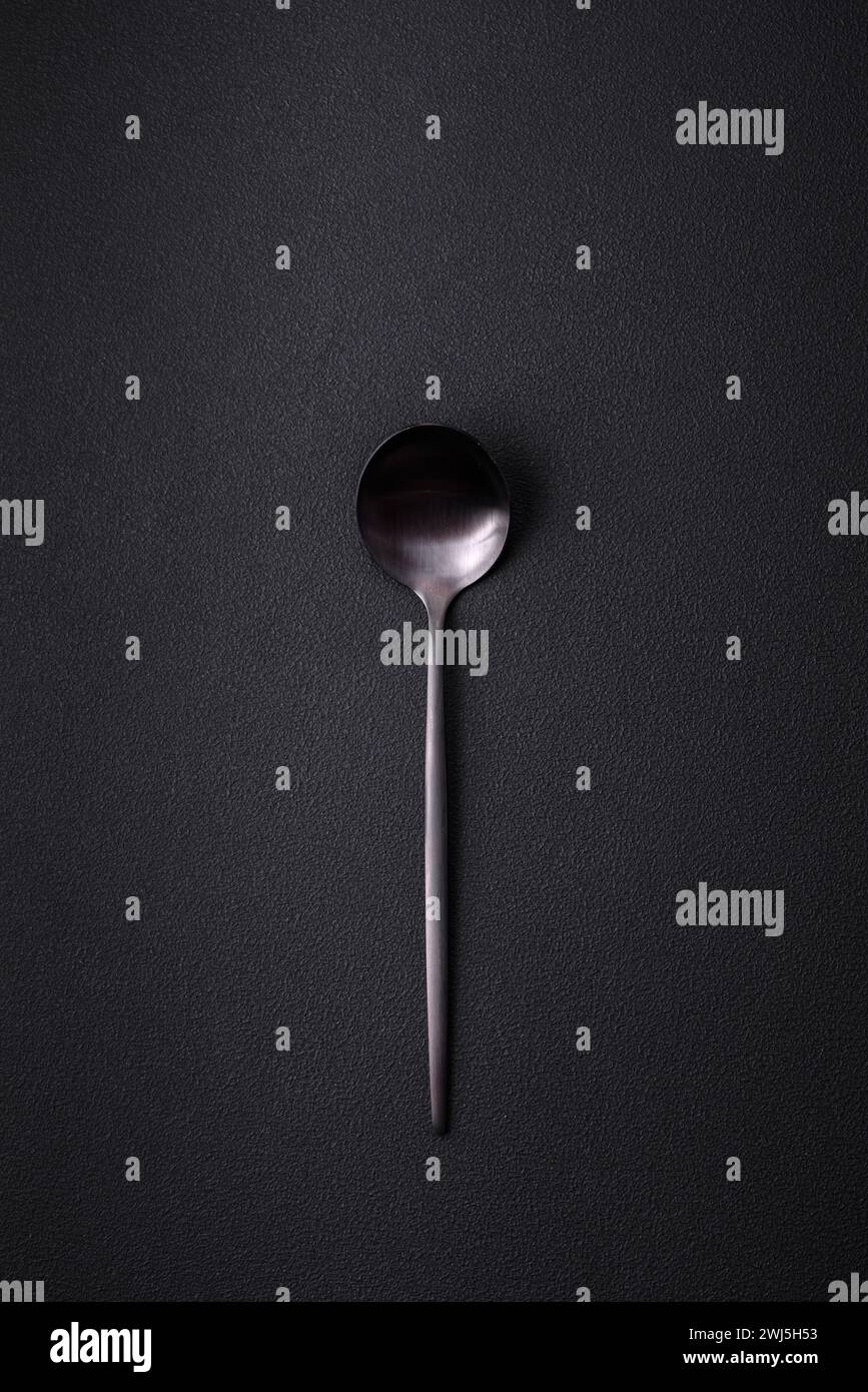 Empty metal spoon on dark textured concrete background. Cutlery Stock ...