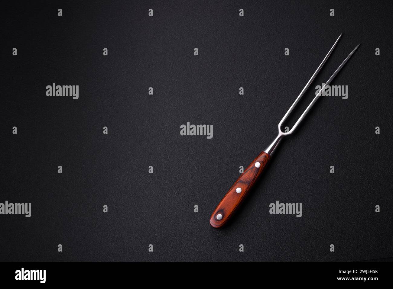 Metal kitchen fork on a dark textured concrete background. Cutlery ...