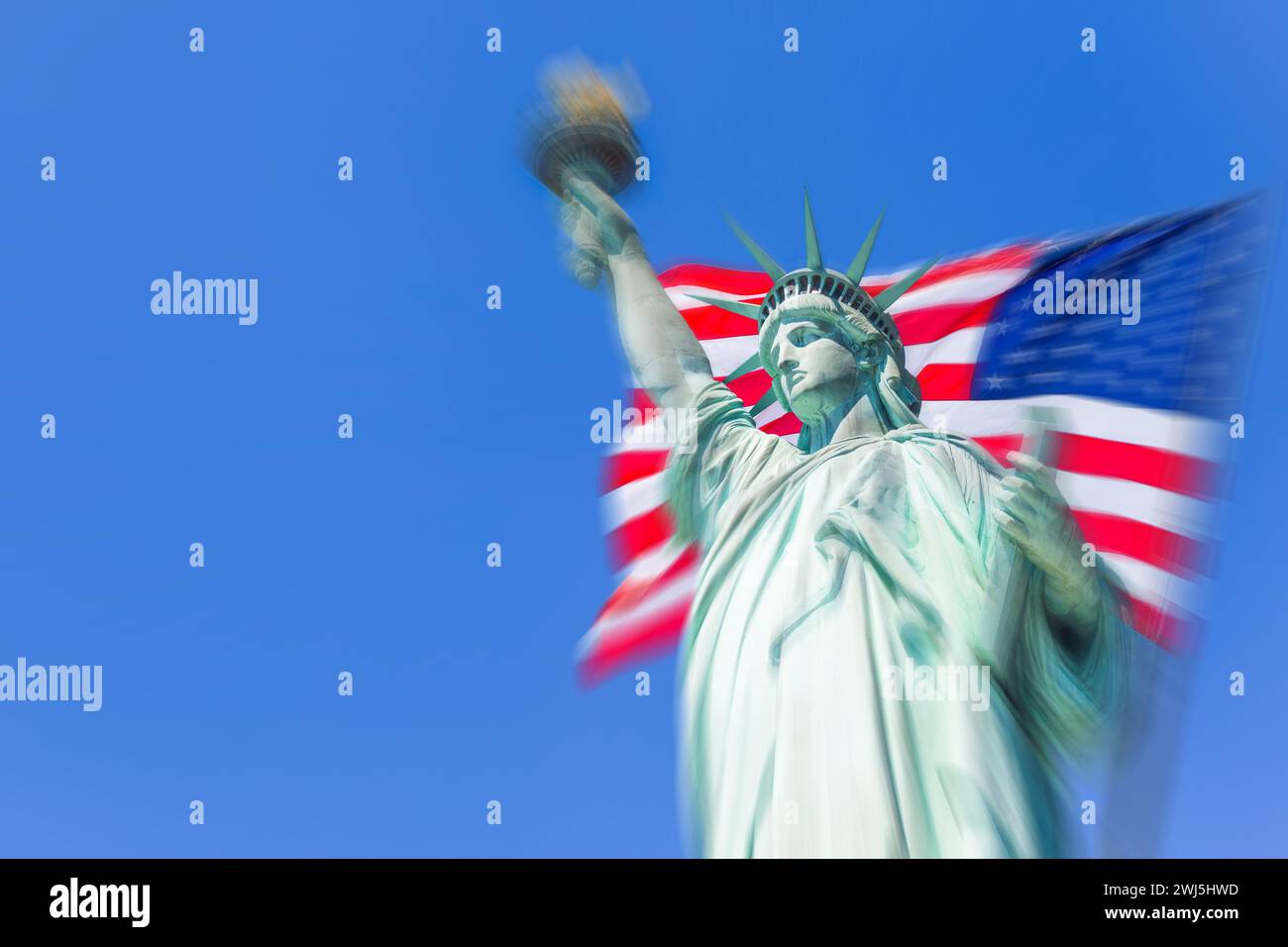 Statue of Liberty with a large american flag with motion blur effect ...