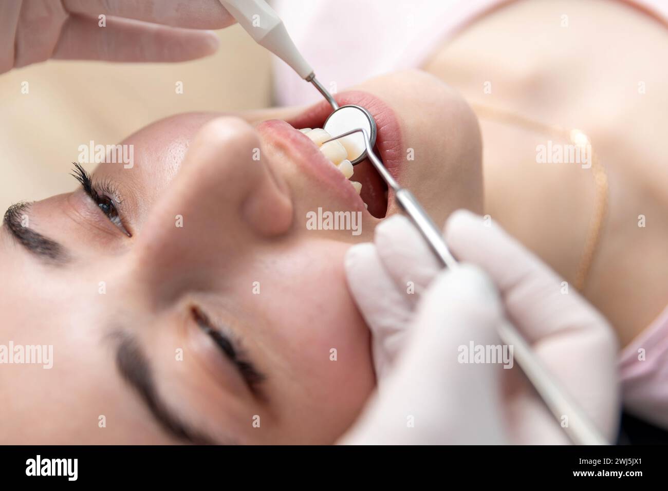 Dentist examining patient teeth with dental mirror during dental check ...