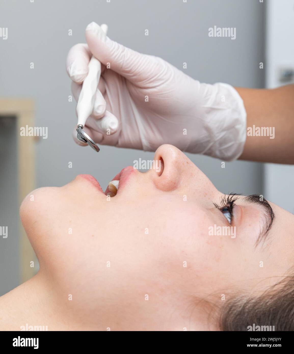 Dentist examining patient teeth with dental mirror during dental check ...