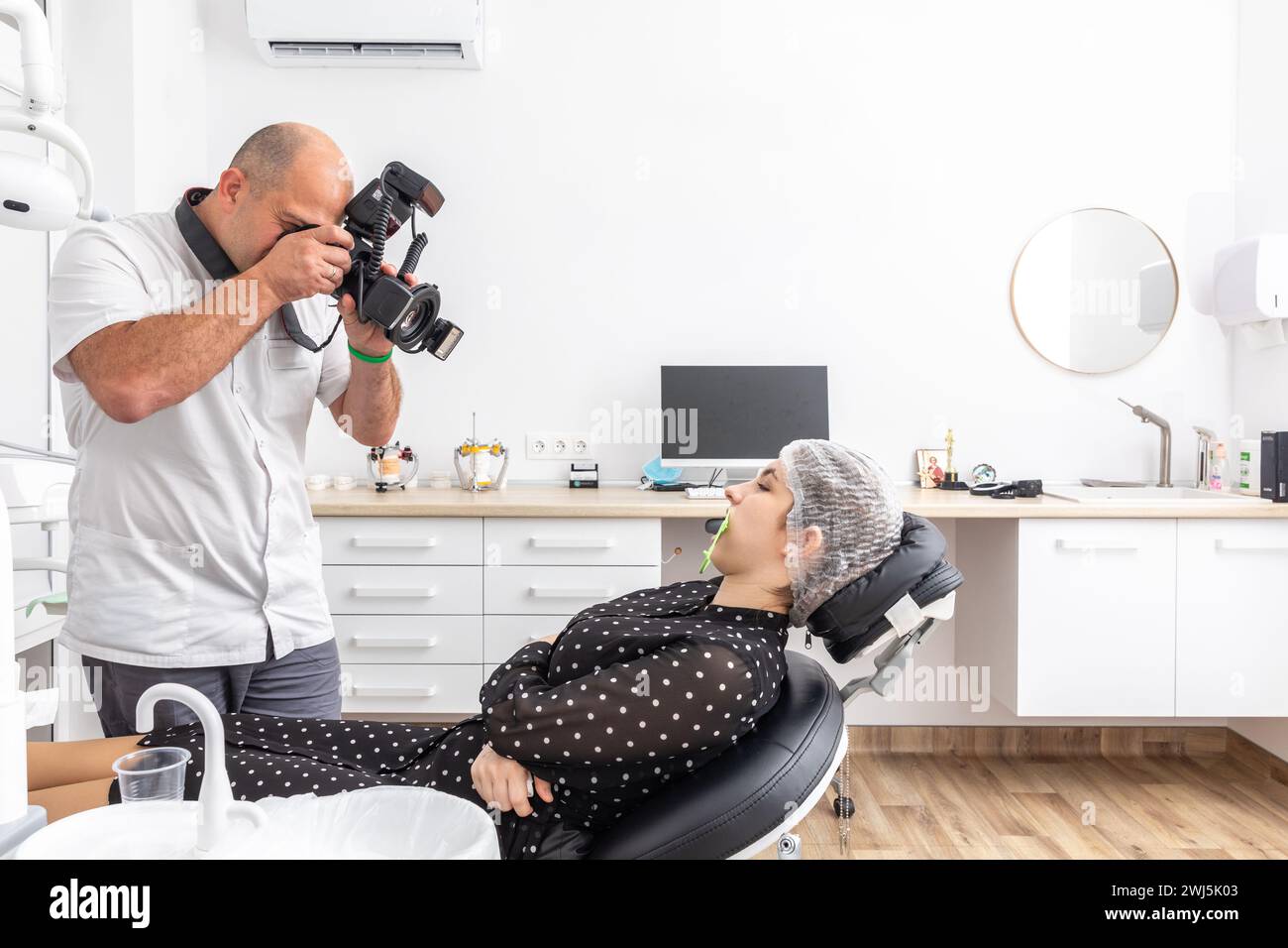 Dentist photographing patient's teeth for medical record before and ...