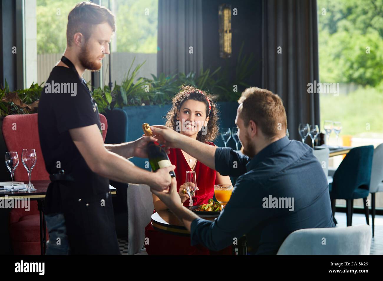 Couple at restaurant and waiter hi-res stock photography and images - Alamy