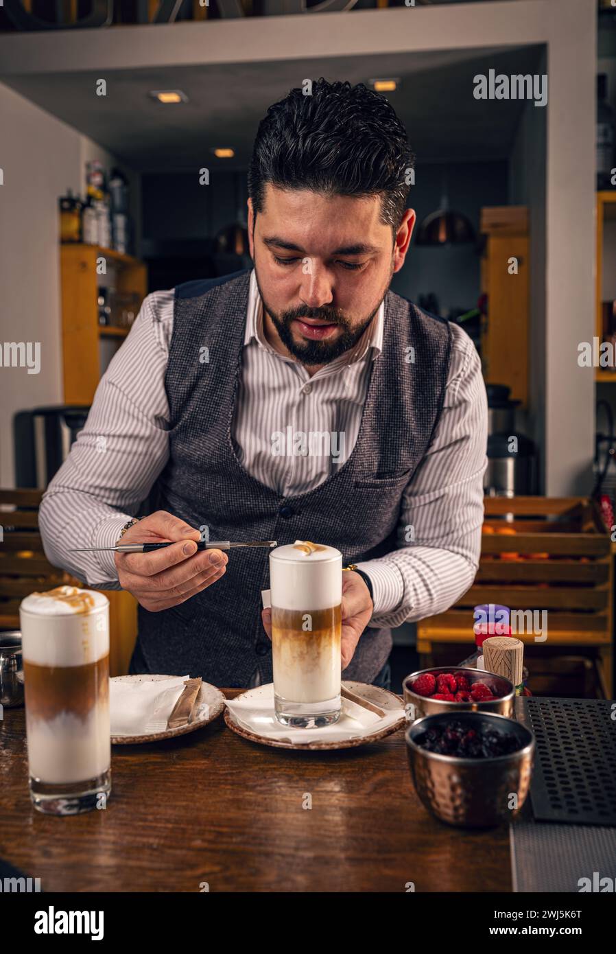 Barista decorating latte macchiato. Coffee speciality in tall glass ...