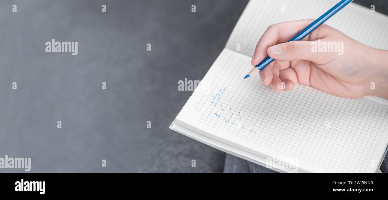Woman's hand makes notes and entries in a notepad Stock Photo - Alamy
