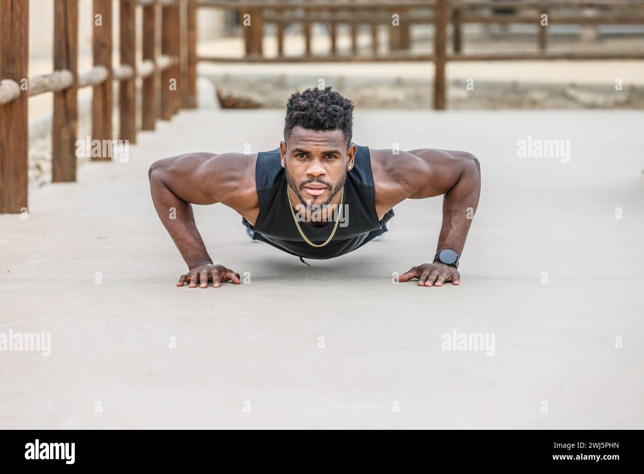 Full body of strong African American sportsman in activewear doing push ...