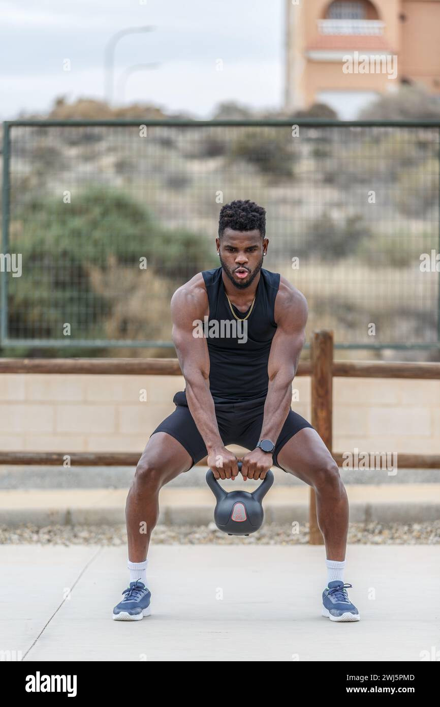 Full body of muscular African American male athlete lifting heavy ...