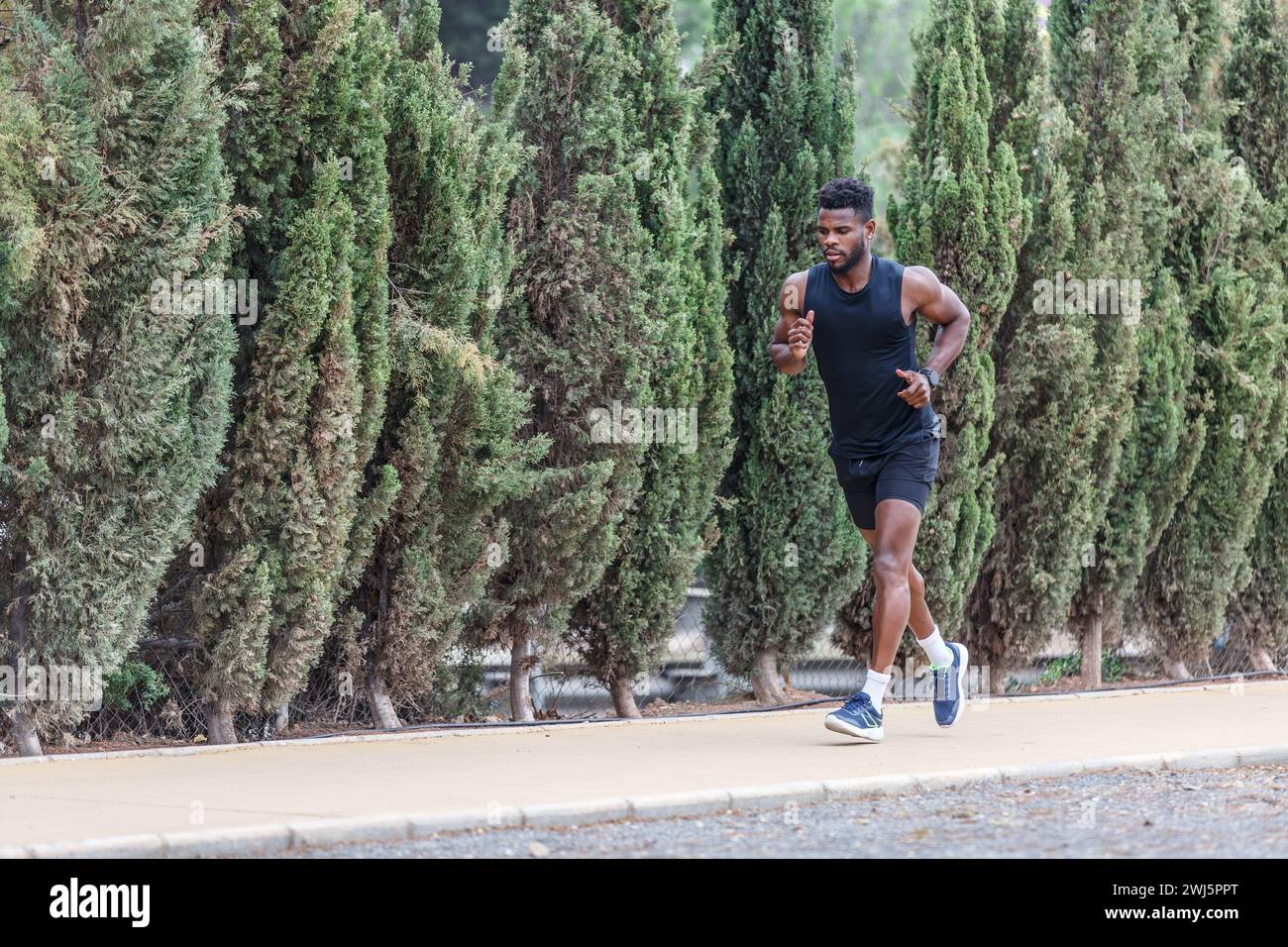 Full body of determined black male athlete in sneakers and sportswear ...