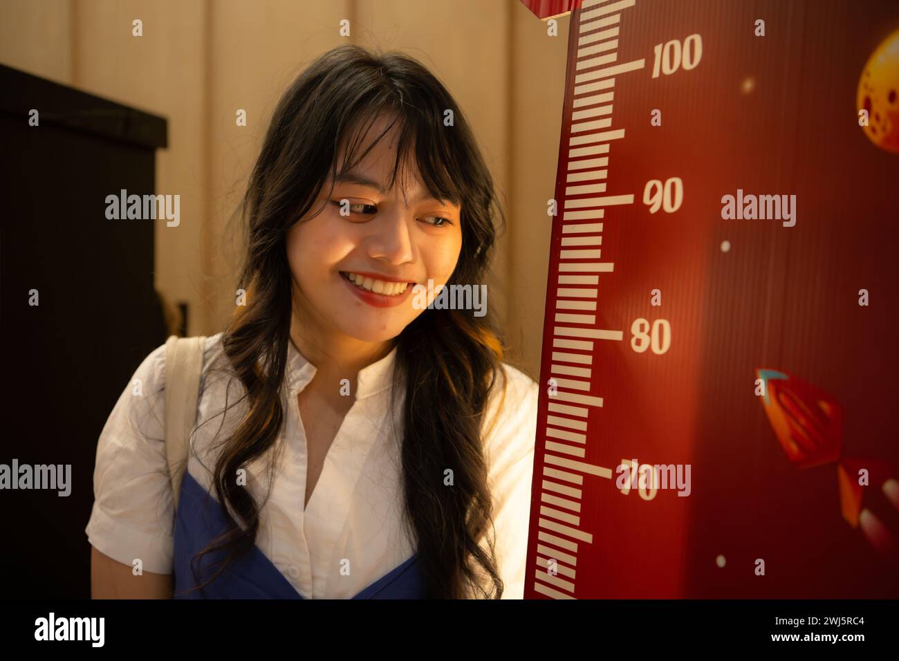 Portrait of an Asian woman with height measurements to pay for child ...