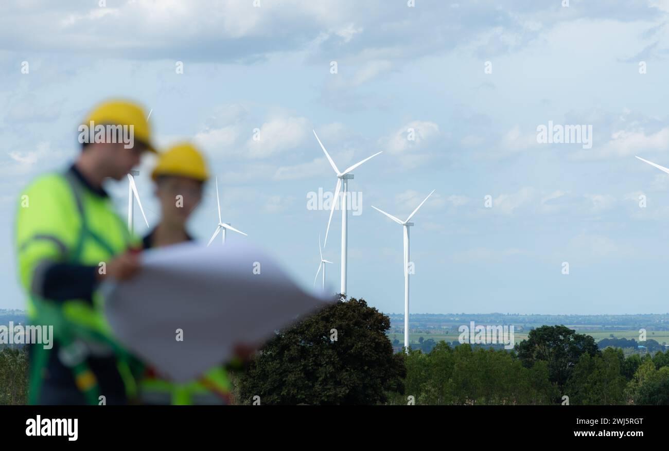 Engineers and wind turbines in a wind farm in the countryside with ...