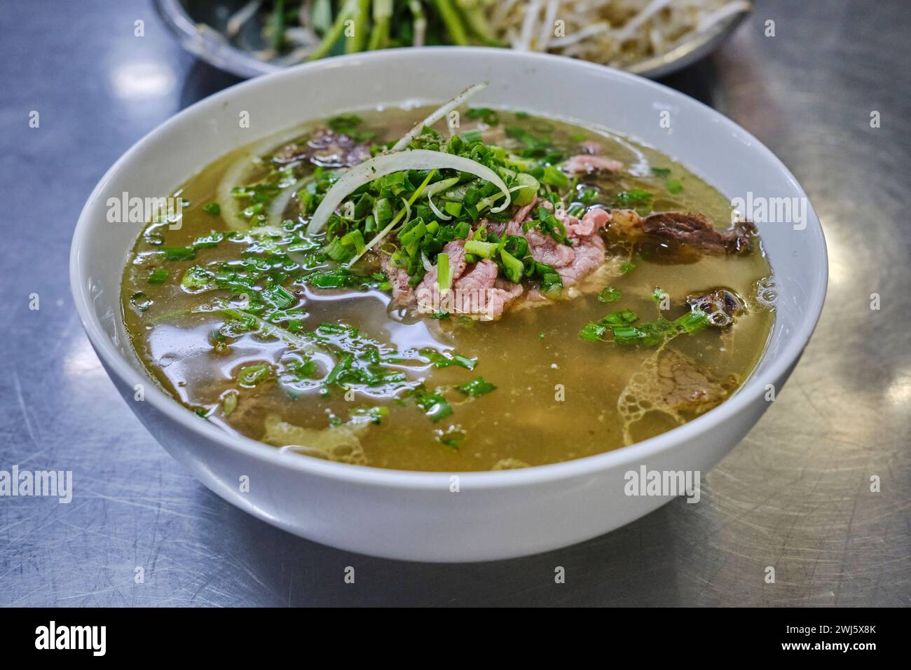 A bowl of beef pho (phở) served with vegetable condiments Stock Photo ...