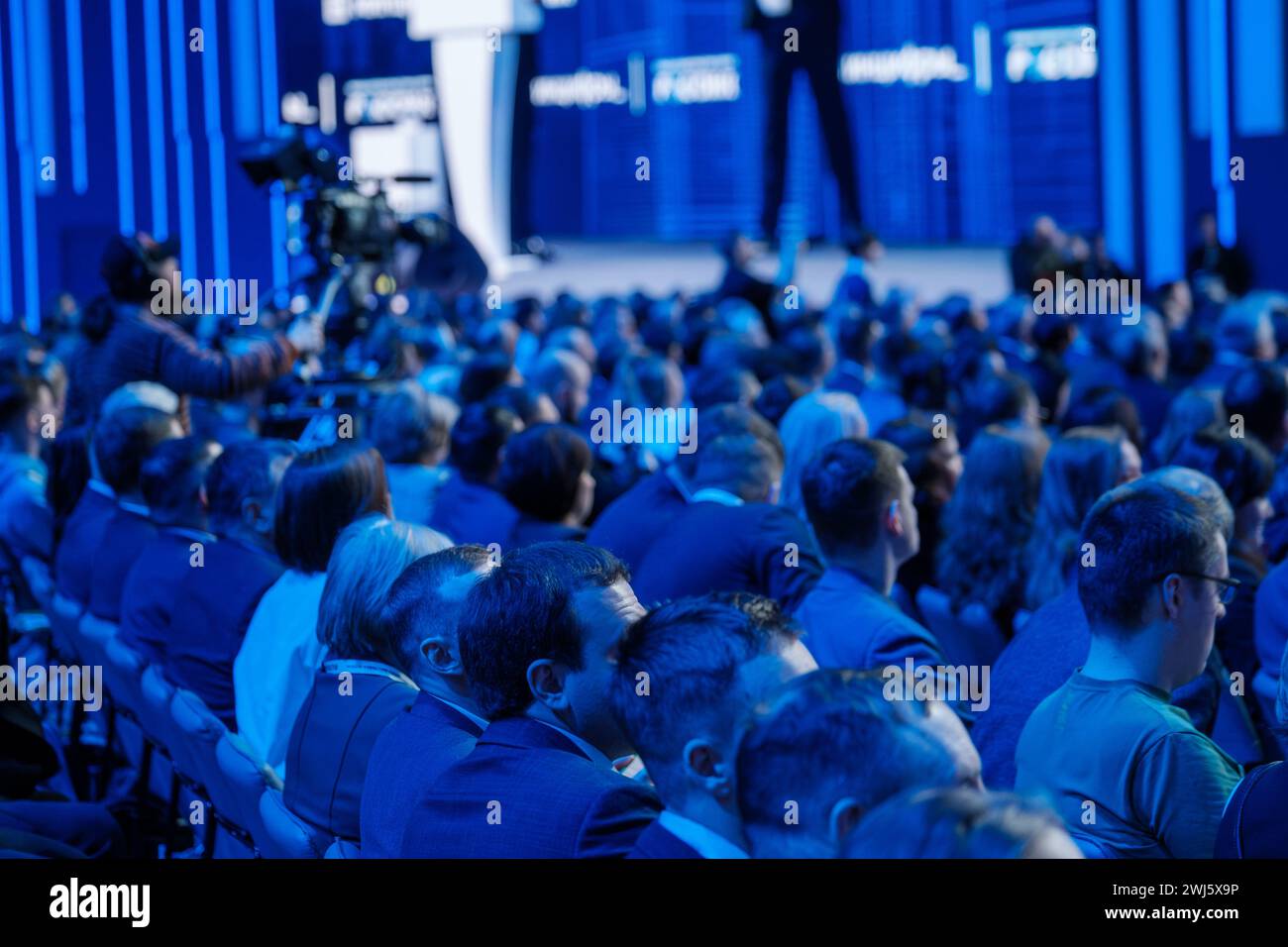 Blurred audience engaging with a speaker at a business conference with ...