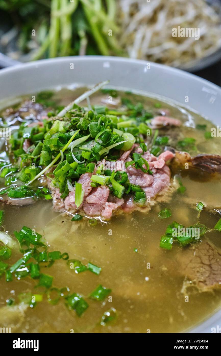 A bowl of beef pho (phở) served with vegetable condiments Stock Photo ...