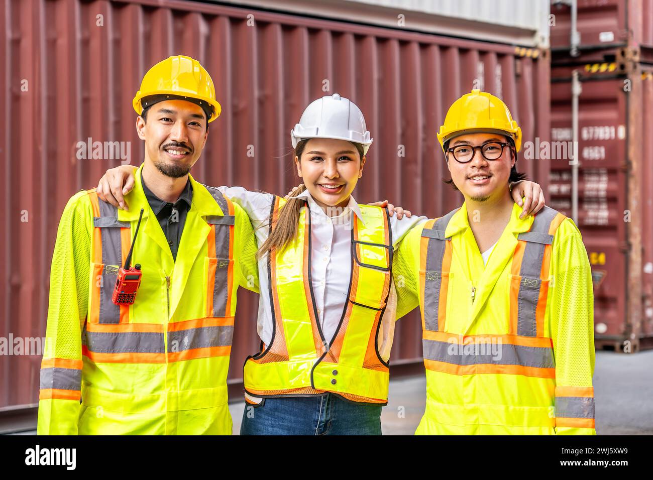 A female worker and two male workers wearing yellow safety vests Stock ...