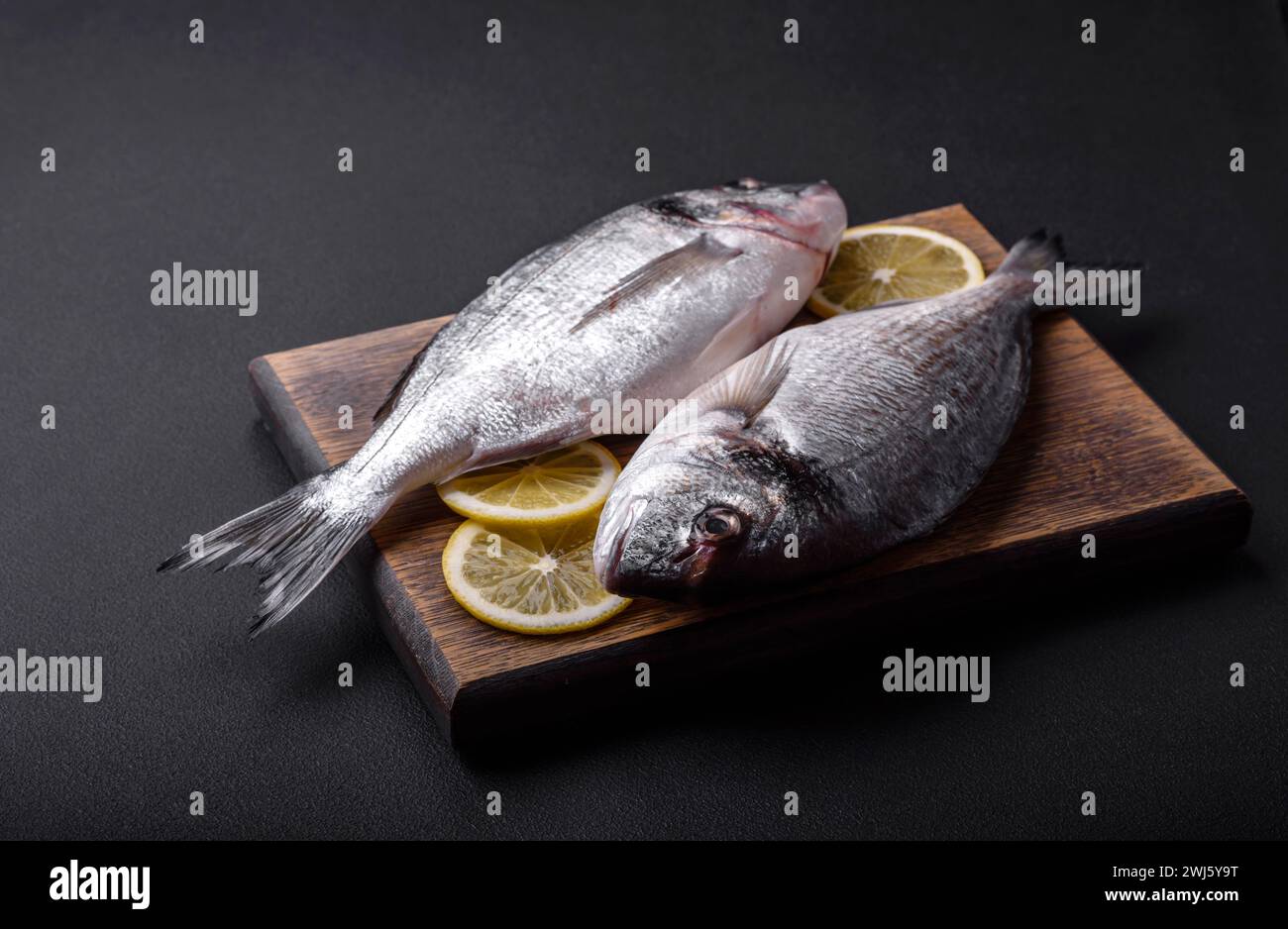 Fresh raw dorado fish with spices, herbs, salt and lemon Stock Photo ...