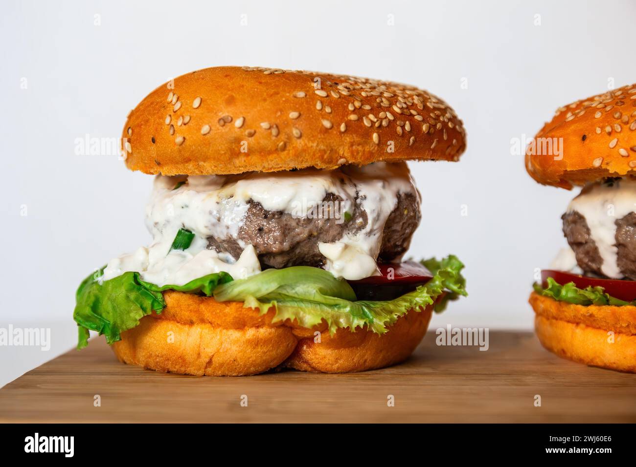 Close-up of a juicy messy burger with an imperfectly stacked patty and ...