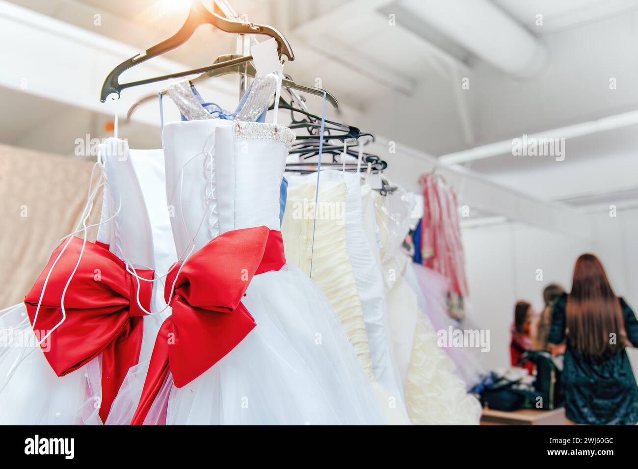 An array of wedding dresses hanging, wedding dress with big rad bow ...