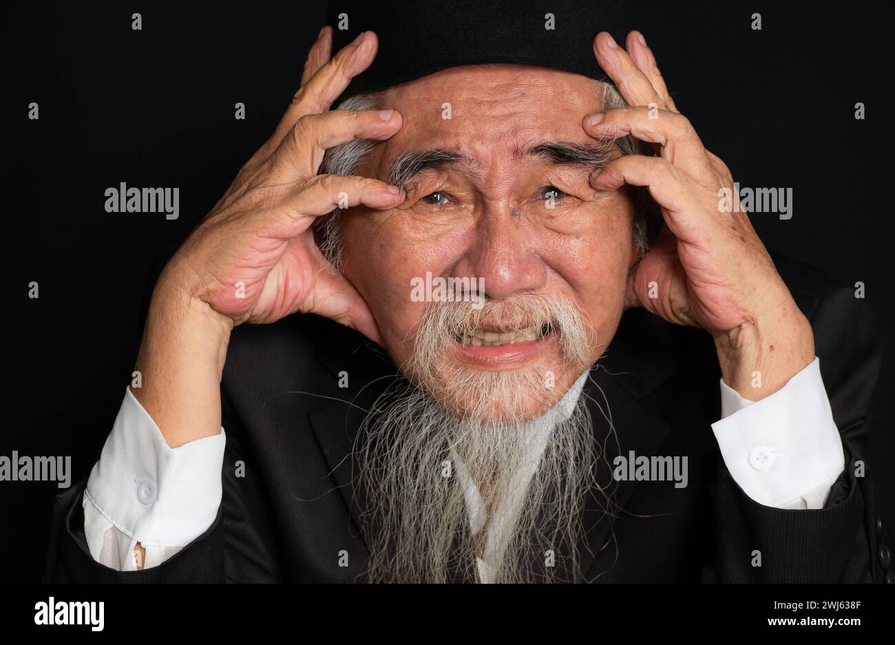 Portrait of a wrinkled-faced old man with a long white beard on a black ...