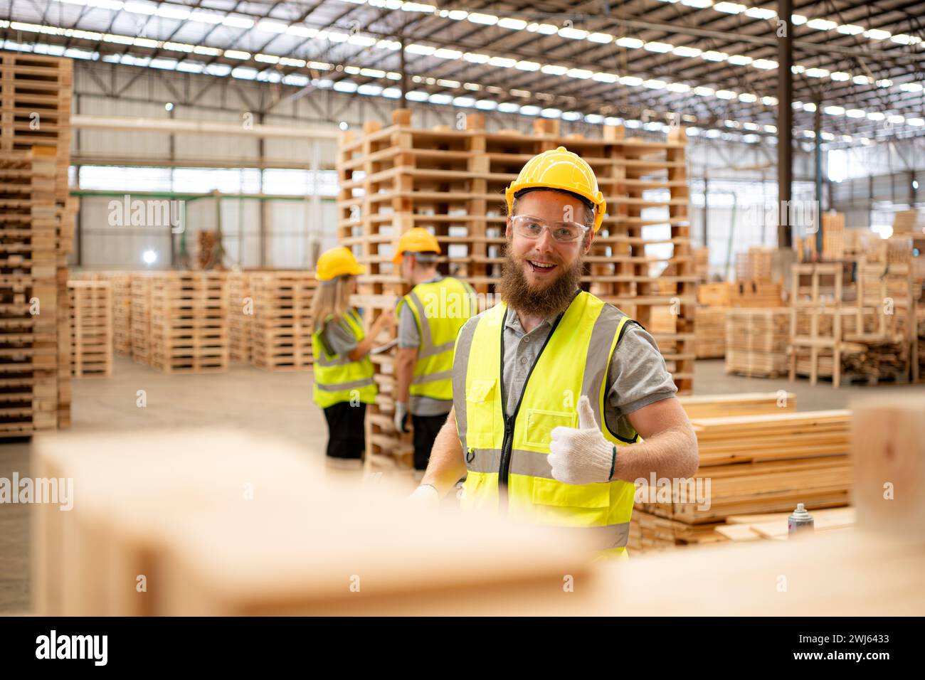 Young workers working in a woodworking factory, Using a hammer to work ...