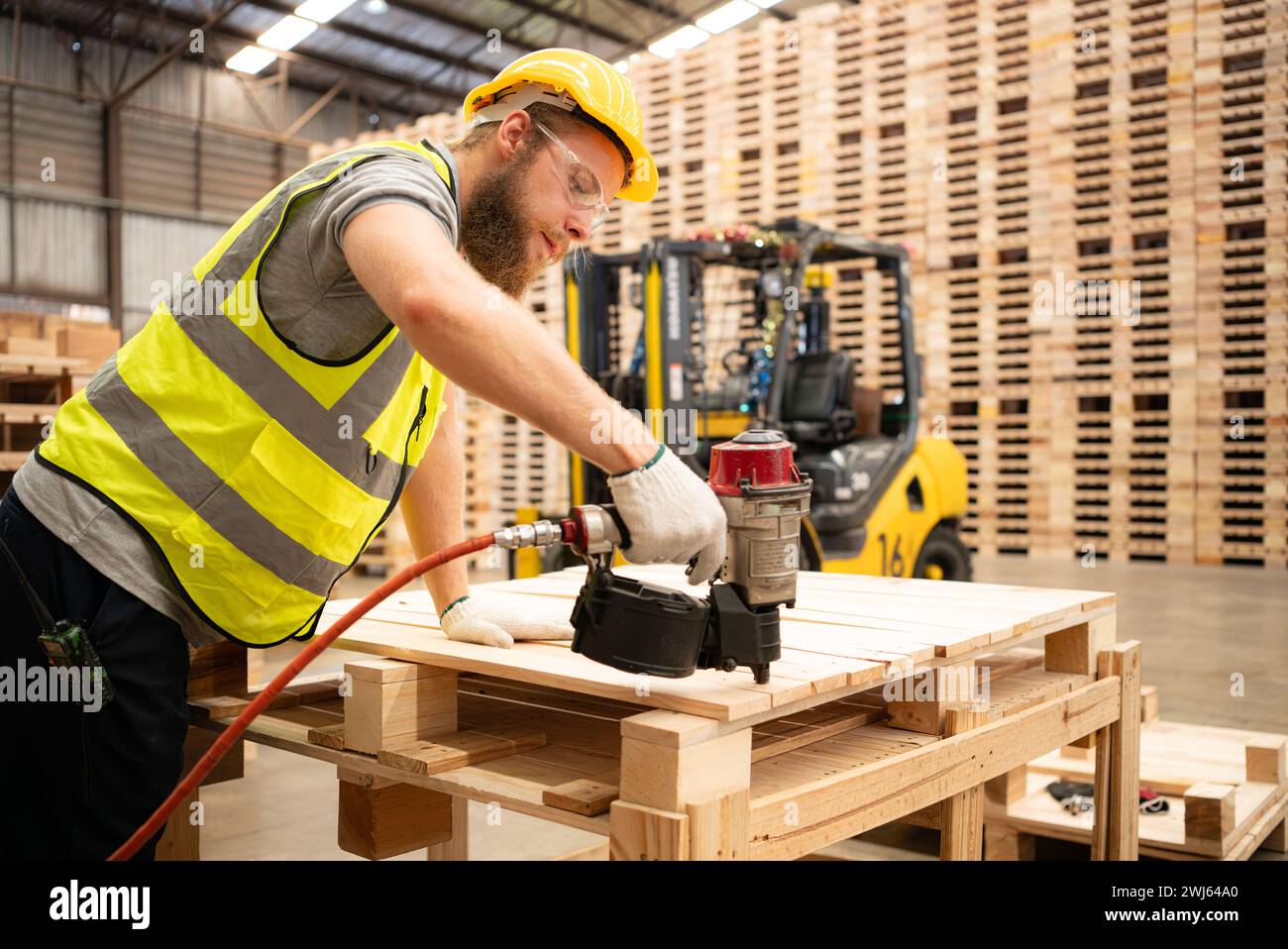 Young workers working in a woodworking factory, Using a nailing machine ...