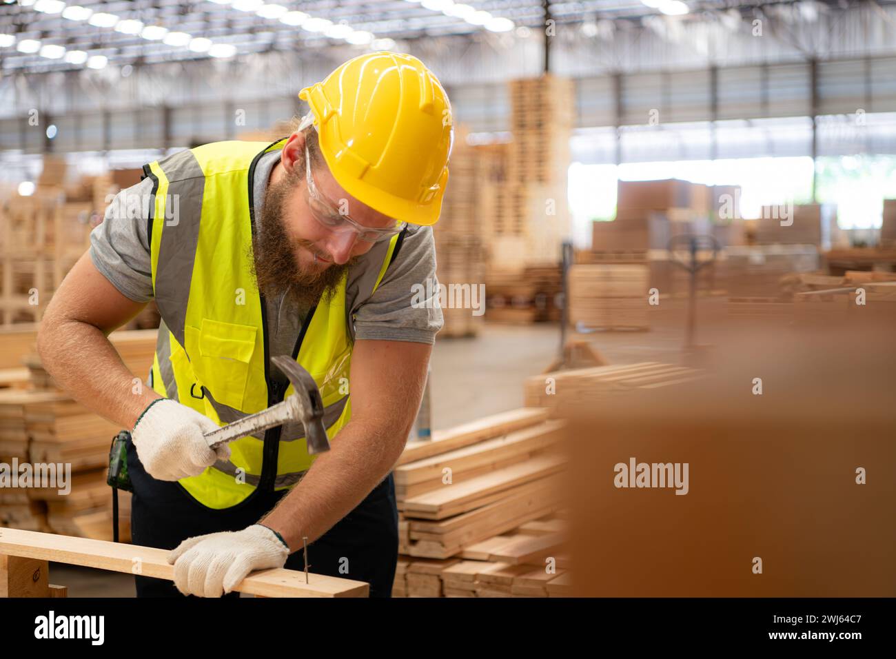 Young workers working in a woodworking factory, Using a hammer to work ...