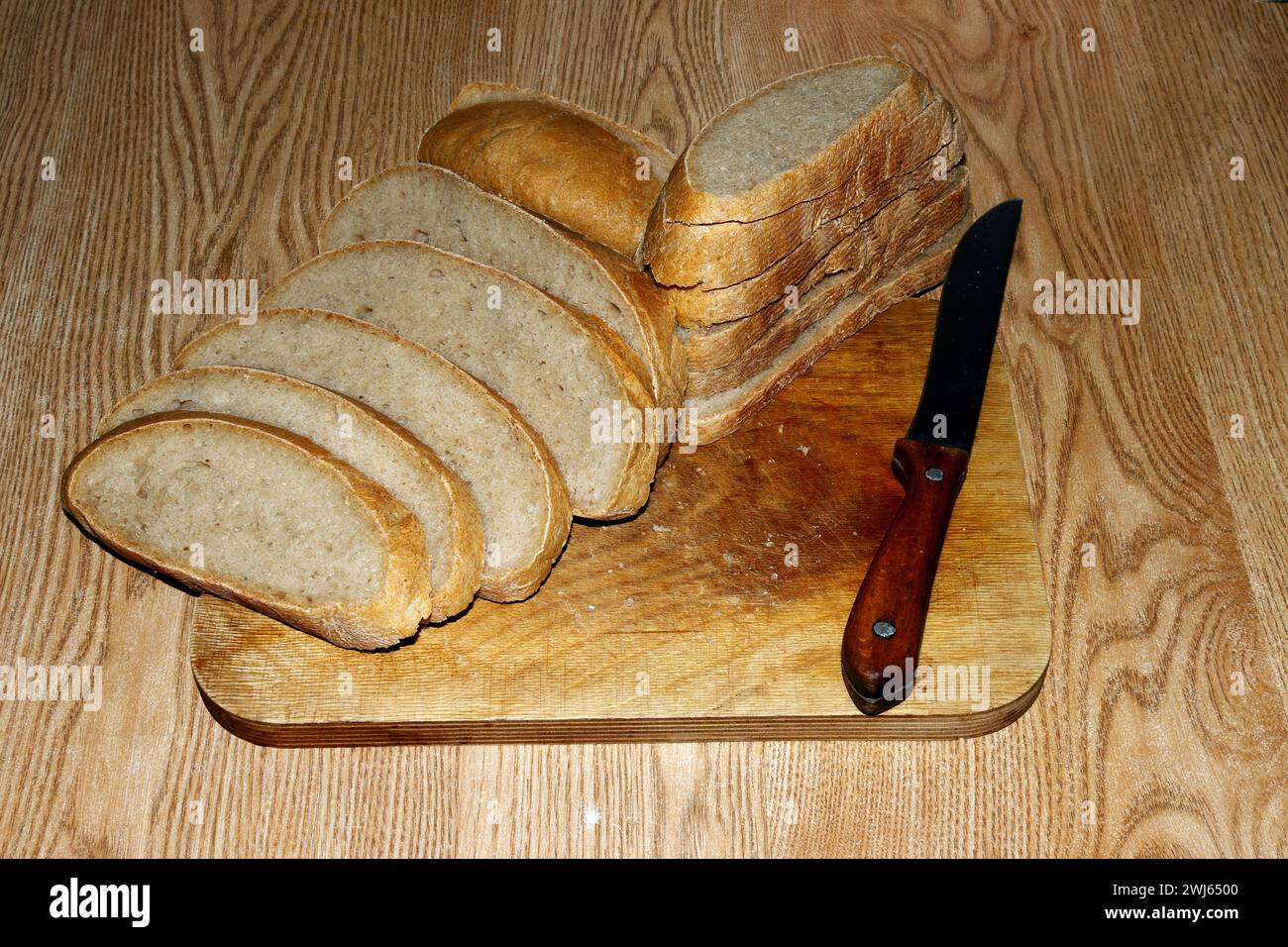 Image of a loaf of bread cut into slices on a kitchen board Stock Photo ...