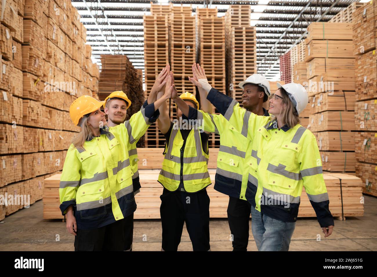 Portrait of happy workers giving high five at warehouse. This is a a ...