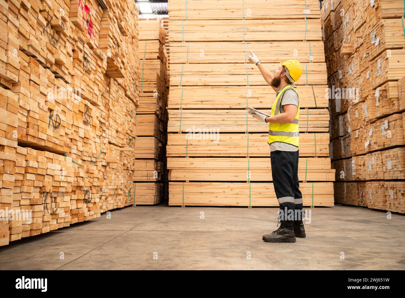 Portrait of warehouse worker checking stock of wooden pallets in ...