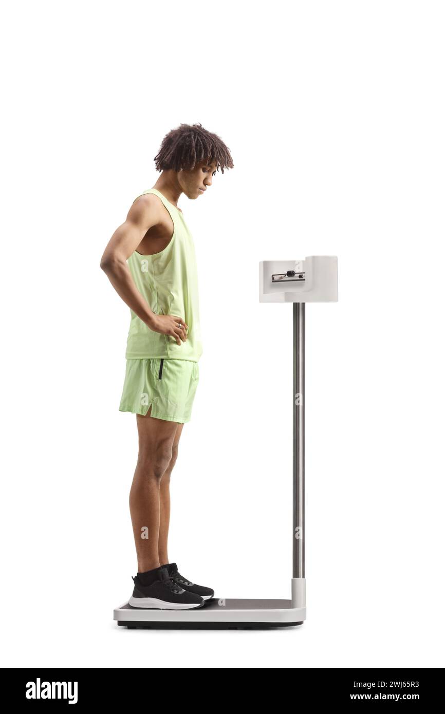 African american guy in sportswear checking weight on a medical scale ...