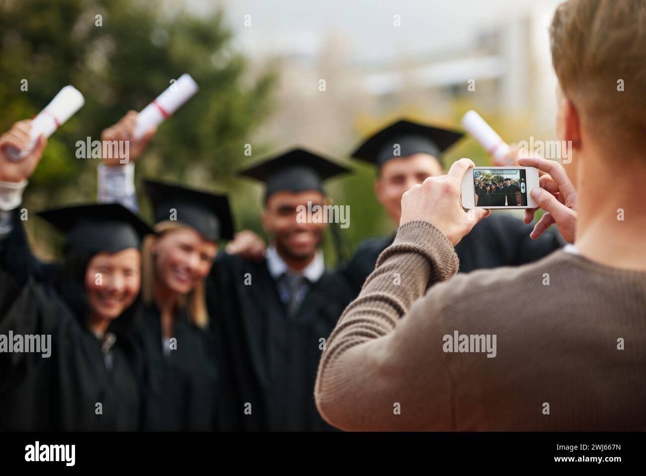 Graduation, certificate and photograph of student friends outdoor on ...