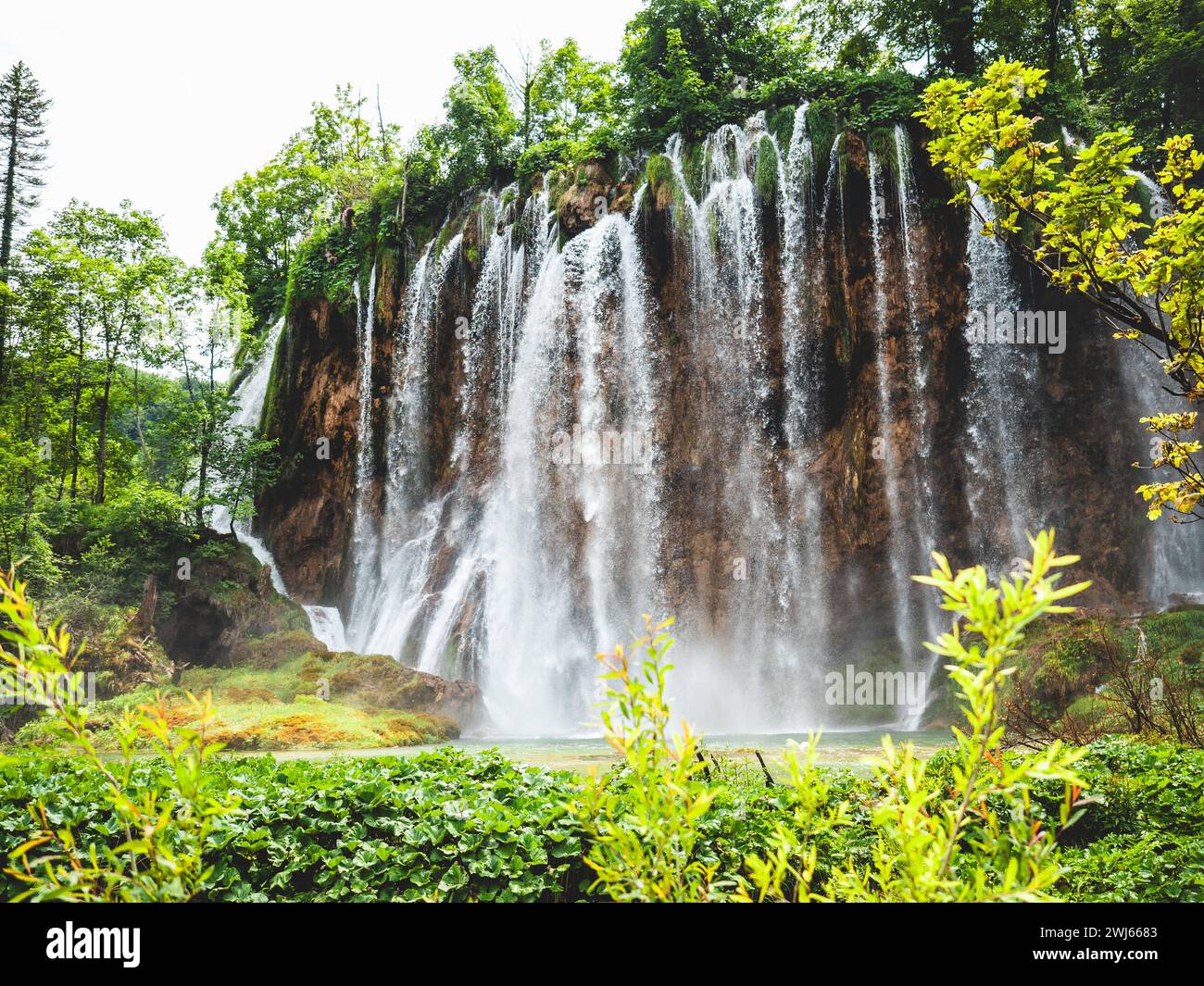 The beautiful waterfalls surrounded by lush greenery in Plitvice Lakes ...