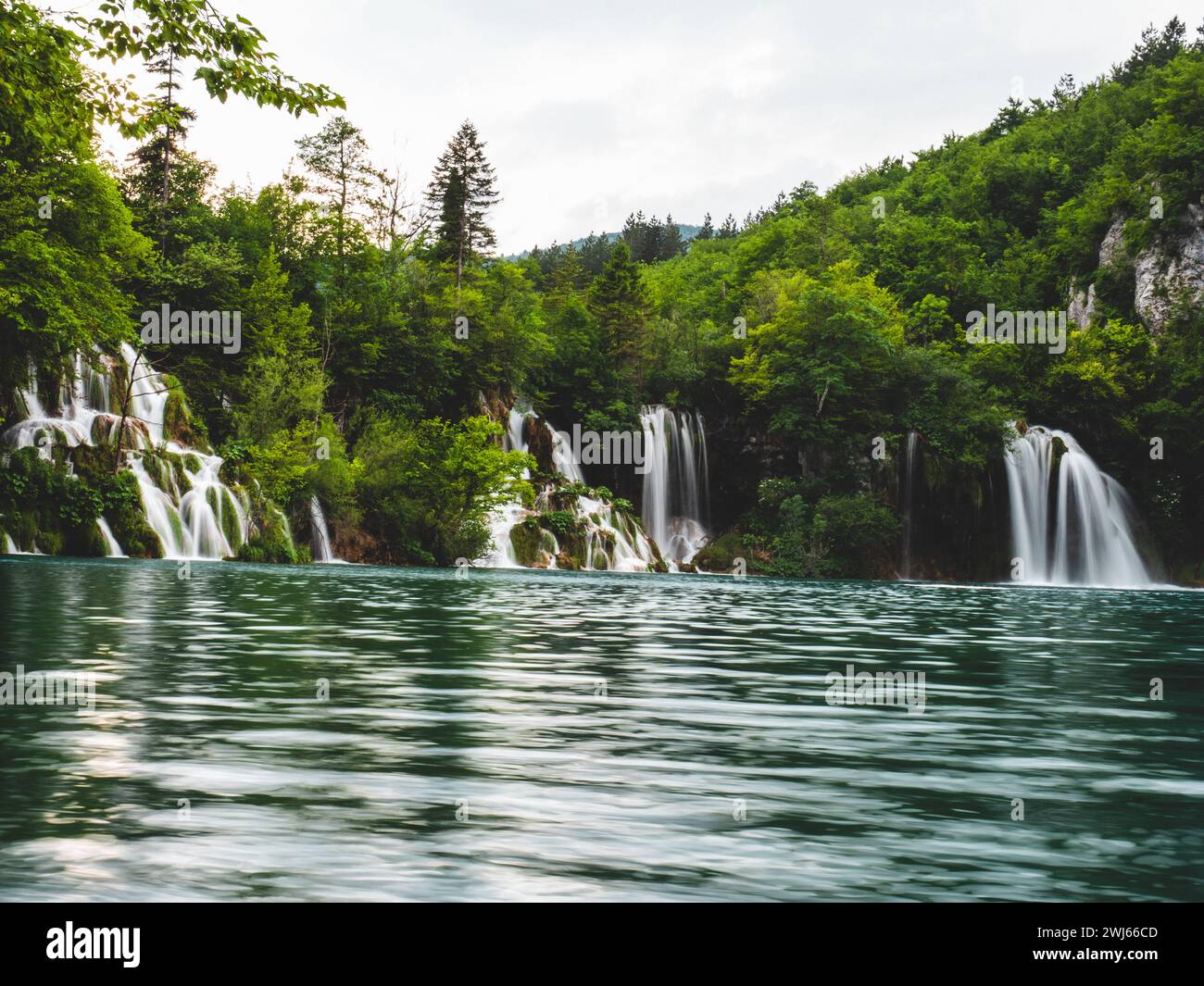 The beautiful waterfalls surrounded by lush greenery in Plitvice Lakes ...