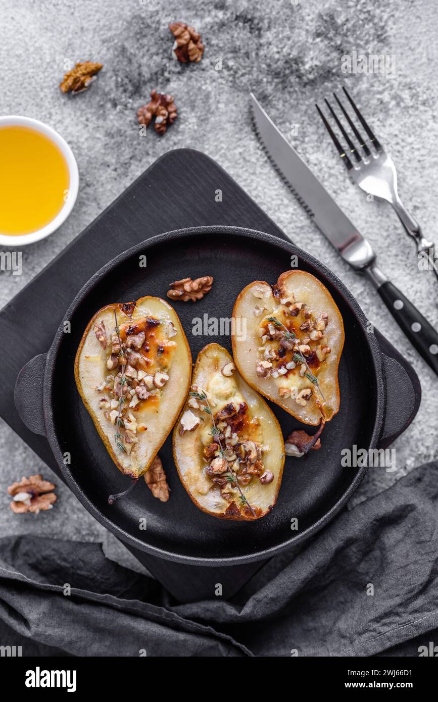 Delicious baked pear with dorblu cheese, walnut and honey on a textured ...