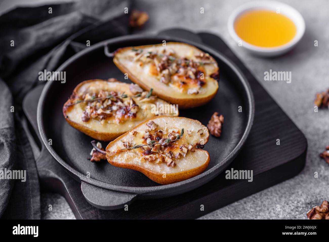 Delicious baked pear with dorblu cheese, walnut and honey on a textured ...