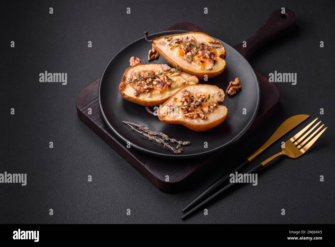 Delicious baked pear with dorblu cheese, walnut and honey on a textured ...