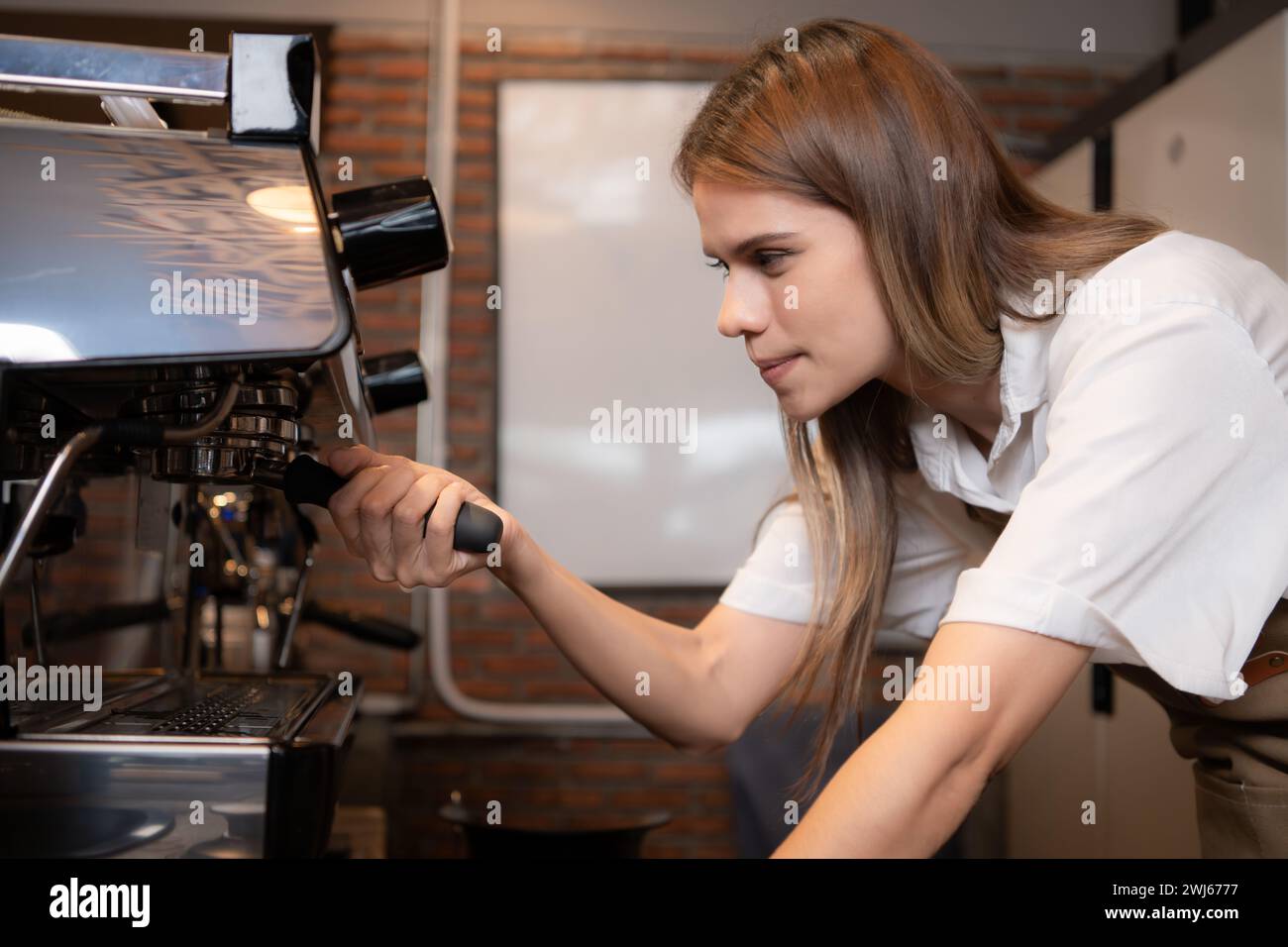 Young female barista preparing coffee in cafe. Female barista using ...
