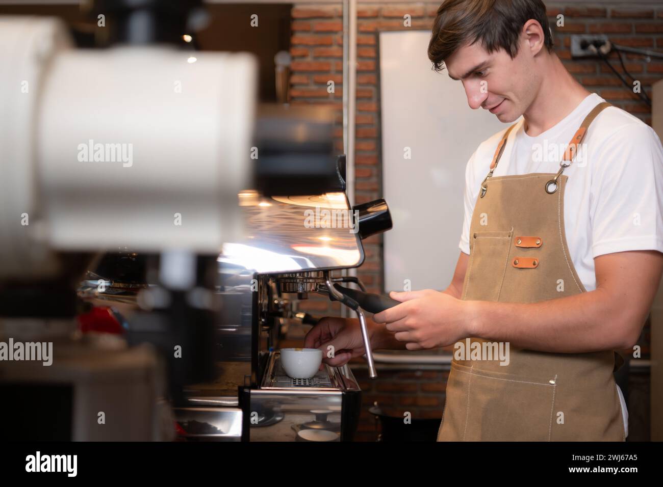 Young male barista preparing coffee in cafe. Male barista using coffee machine Stock Photo - Alamy