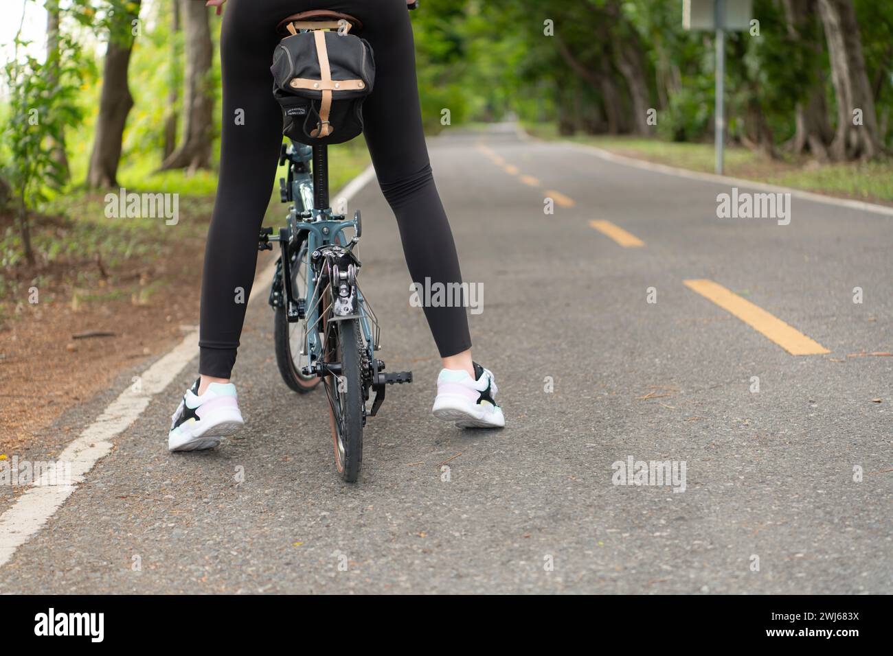 Young woman cyclist riding bike on road in park. healthy lifestyle ...