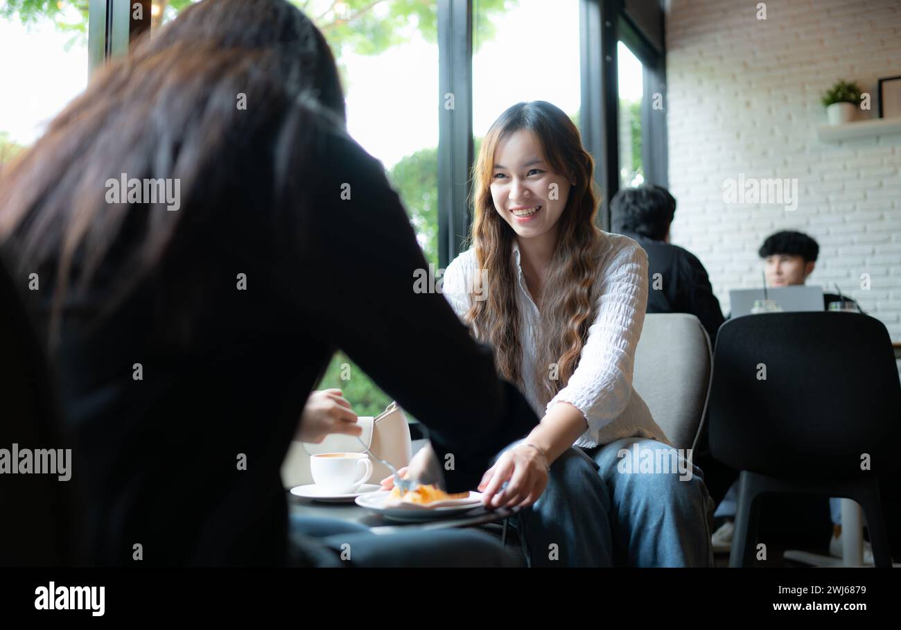 Young asian woman sitting in cafe and drinking coffee with friends ...