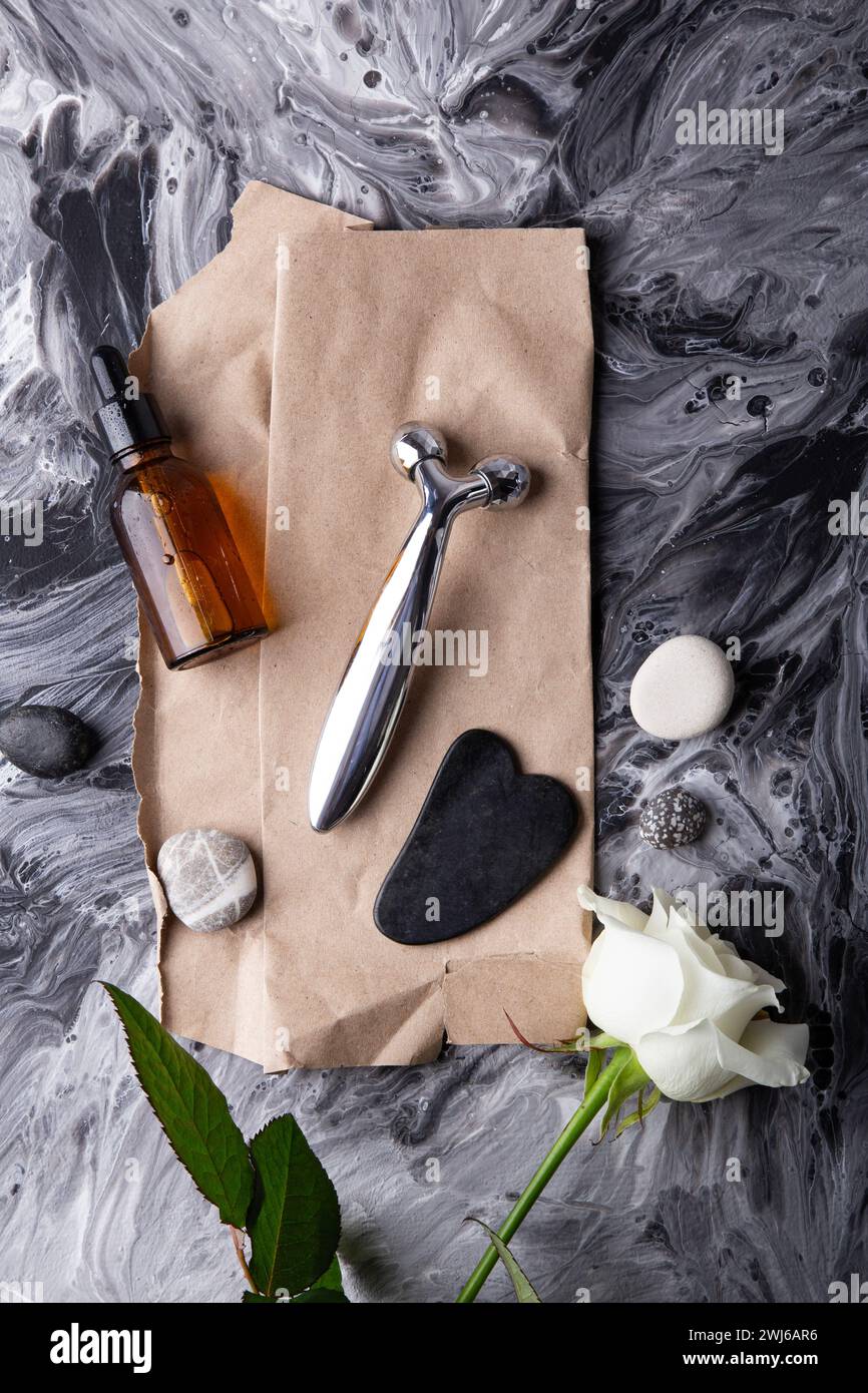 Elegant white rose with massage roller, serum, gua sha and organic ...