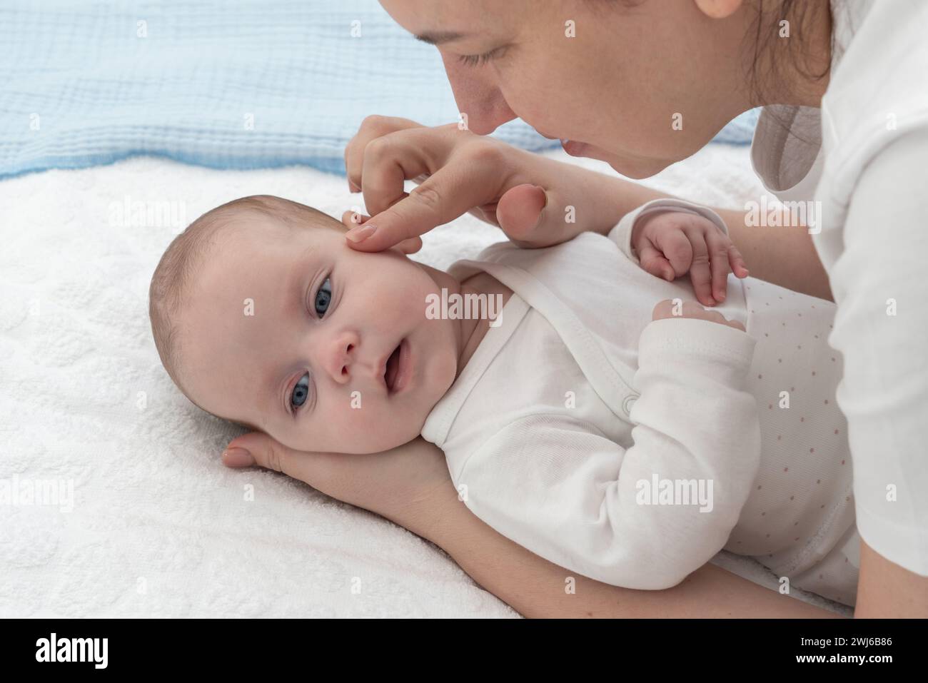 The mother gently touches the baby head with her finger Stock Photo - Alamy